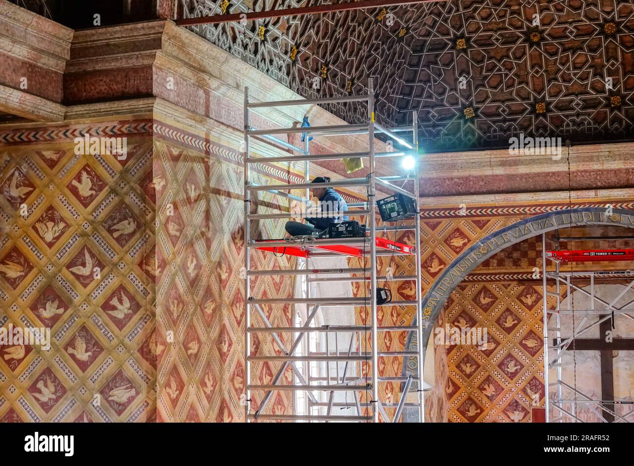 A worker restores the 15th century pigeon wall motif inside the ...