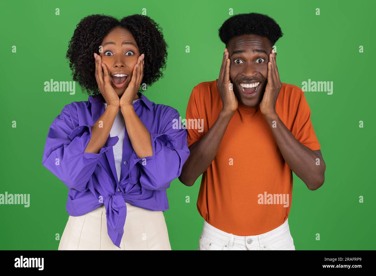 Happy shocked young african american woman and guy in casual with open ...