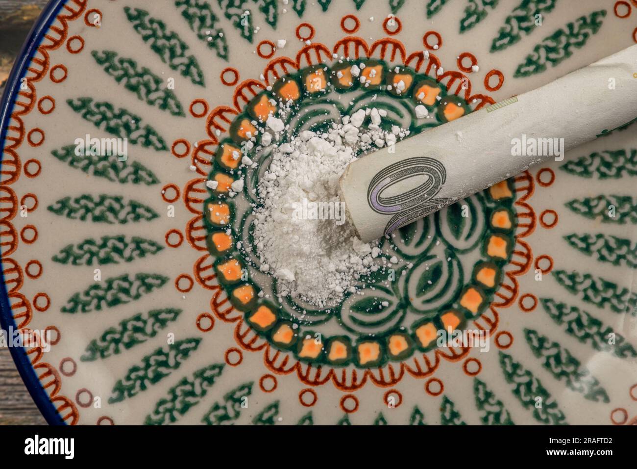 Small plate on old wooden color table with white powder of cocaine with ...