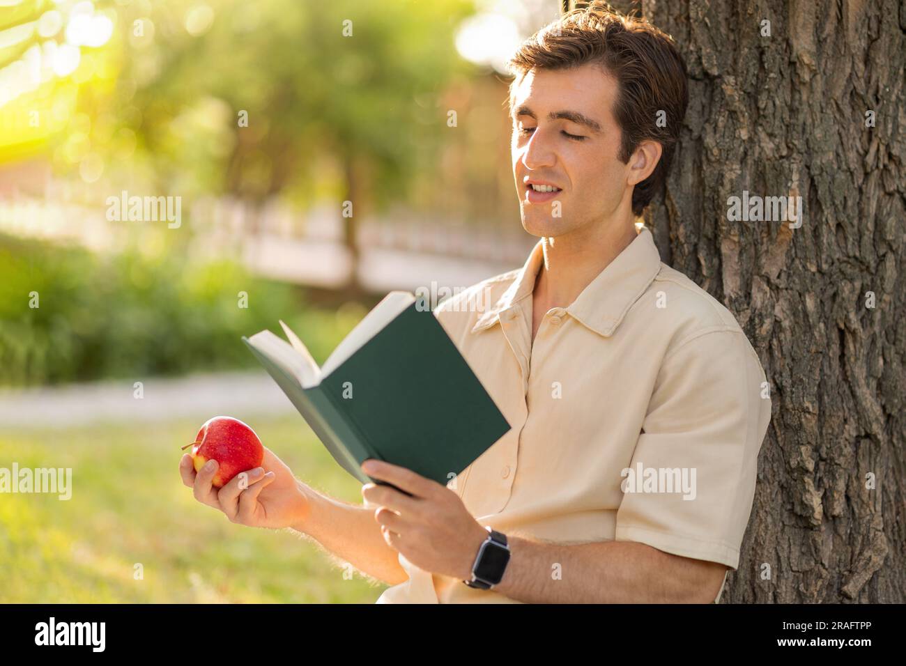 Man sitting under tree reading hi-res stock photography and images - Alamy