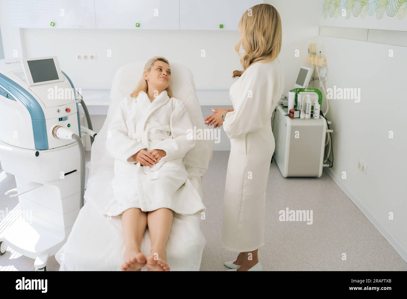 Wide shot of pretty young woman patient talking to doctor during health ...