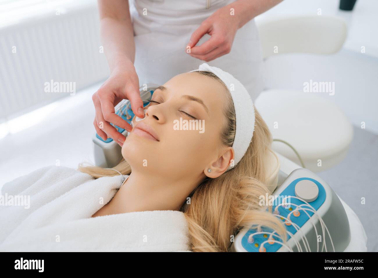 Detail cropped shot of unrecognizable beautician applying electrodes of ...