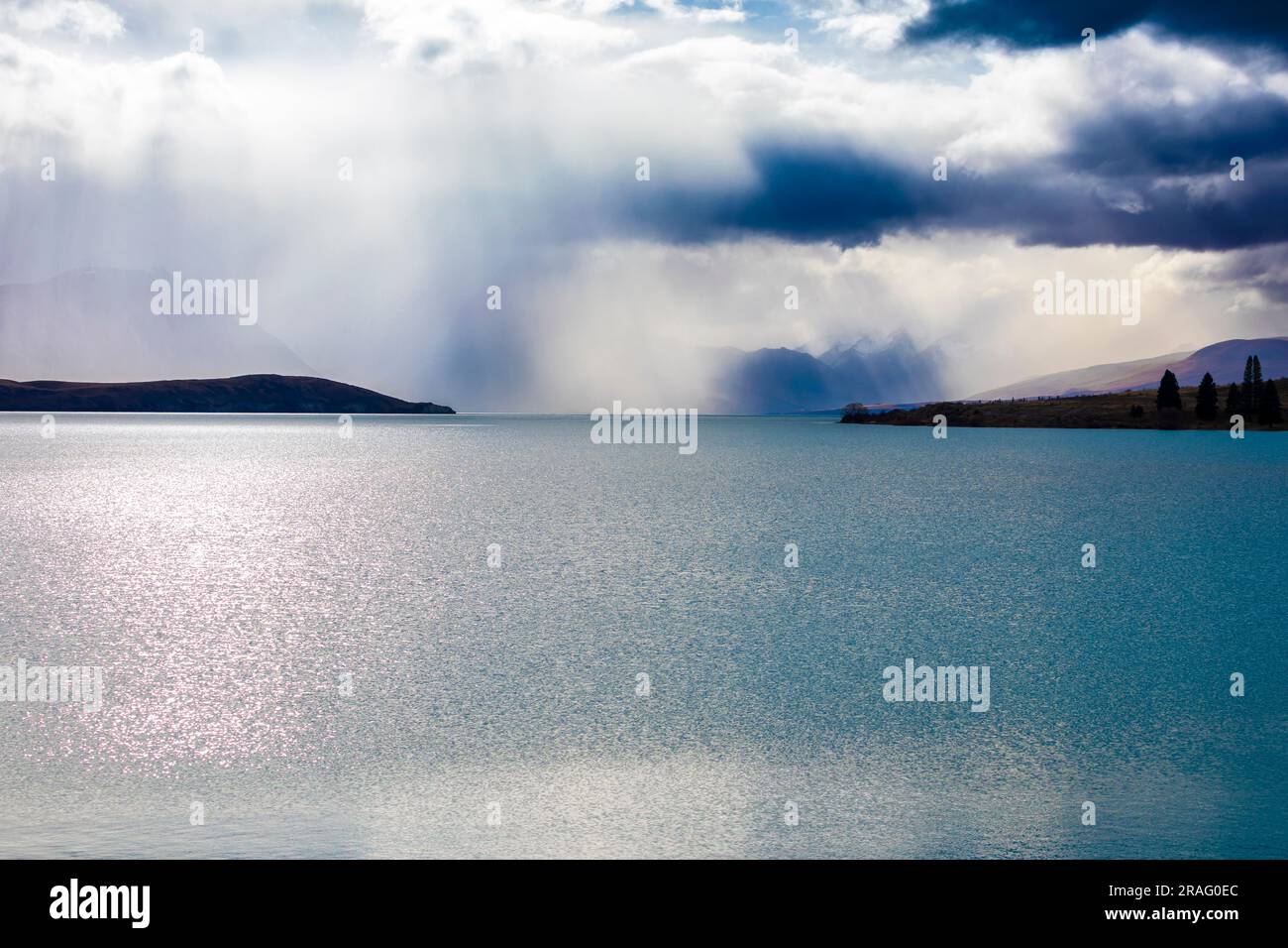 Photograph of early morning sun shining through rain clouds on Lake ...