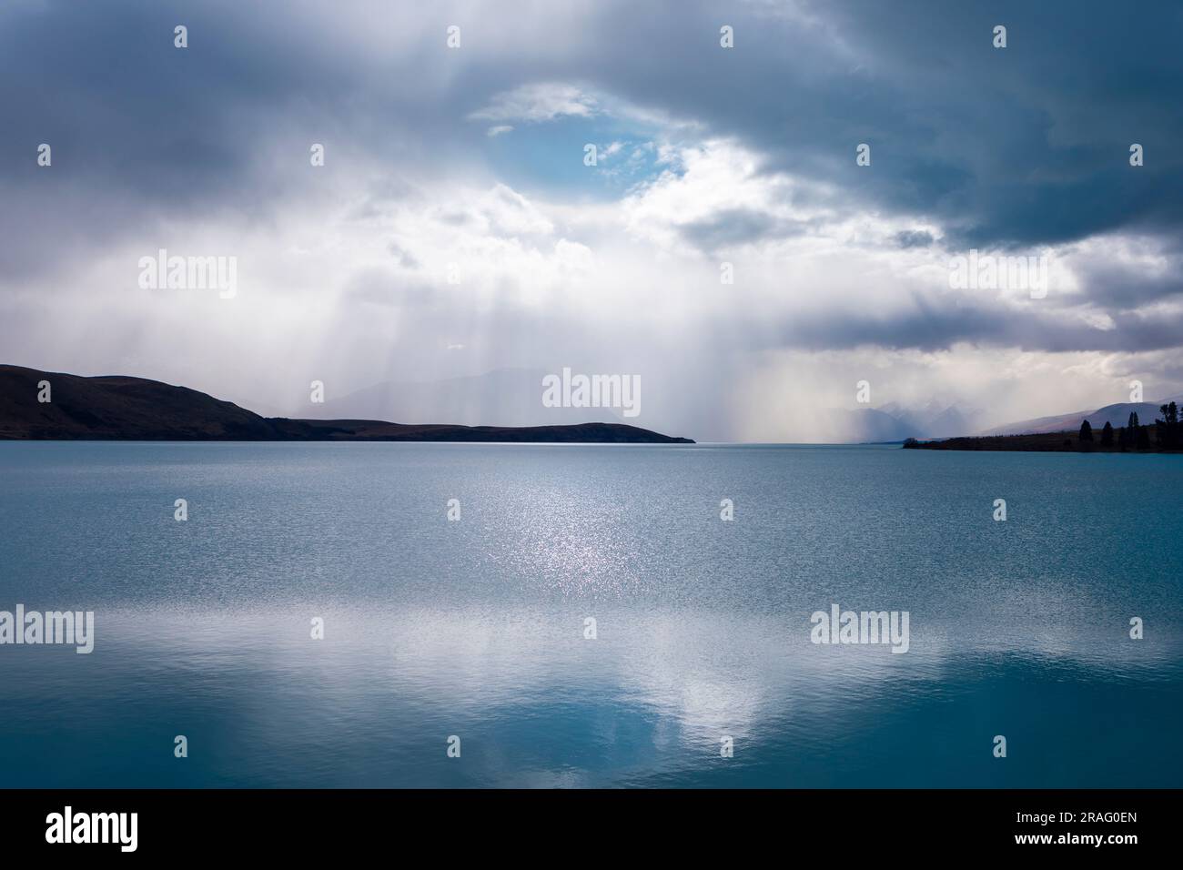 Photograph of early morning sun shining through rain clouds on Lake ...