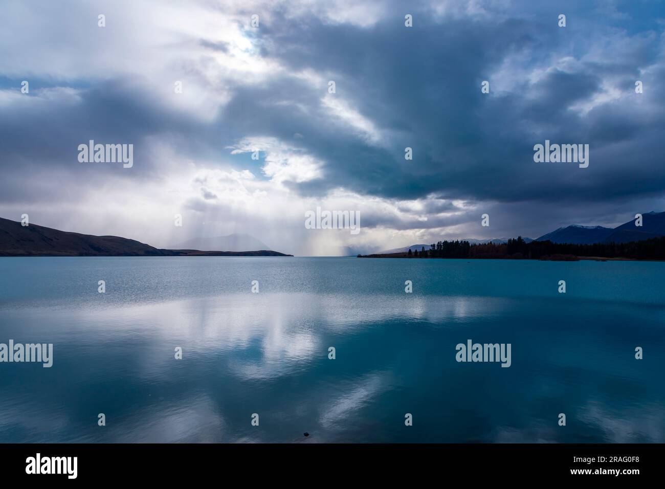 Photograph of early morning sun shining through rain clouds on Lake ...