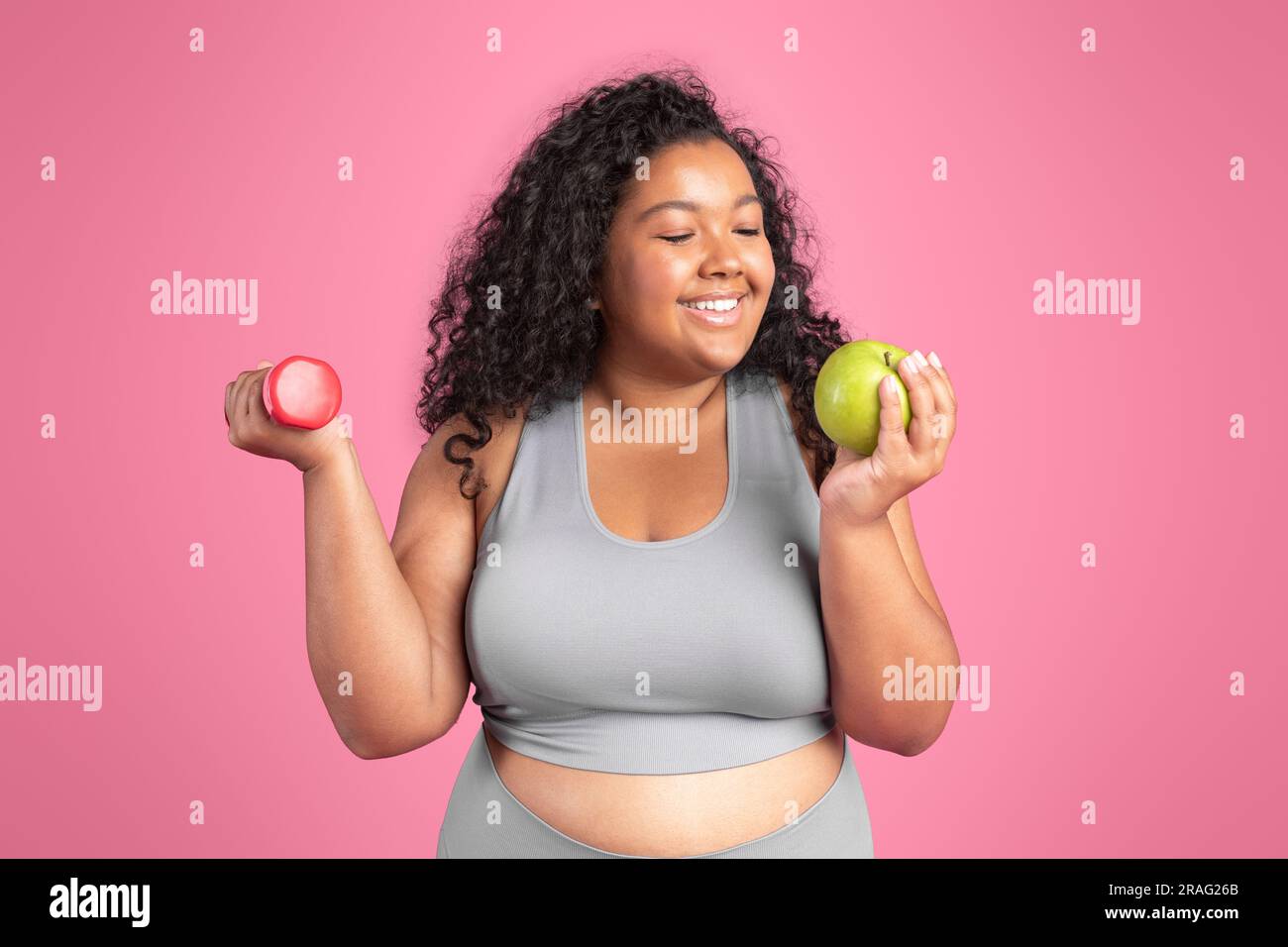 Healthy diet concept. Happy black body positive woman holding dumbbell ...