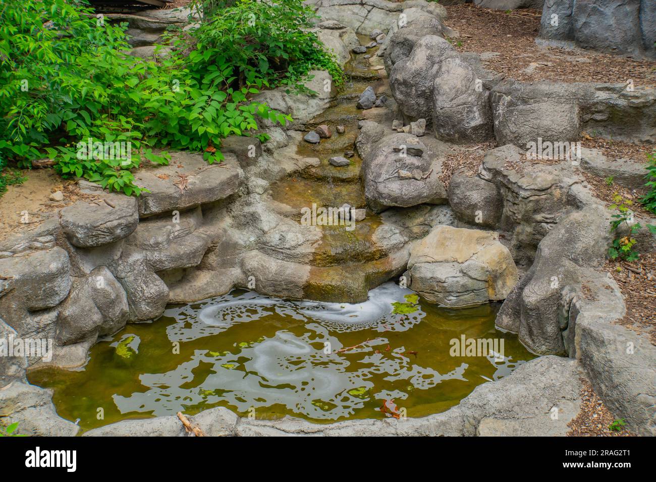 Small artificial waterfall made of granite stones. A waterfalls made of ...