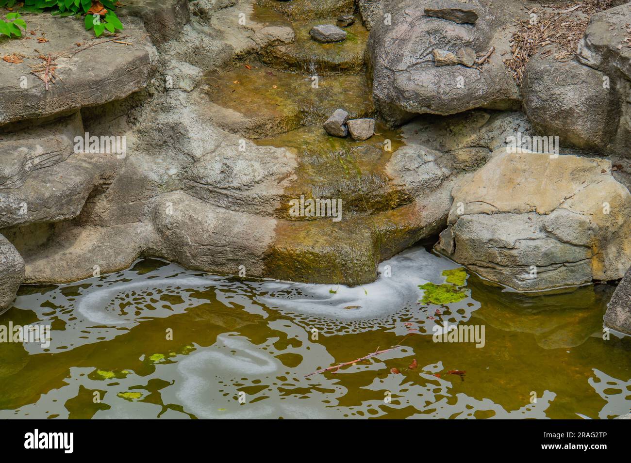 Small artificial waterfall made of granite stones. A waterfalls made of ...