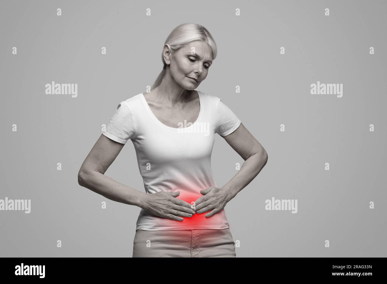Sick mature lady having stomach ache, touching abdomen with red ...