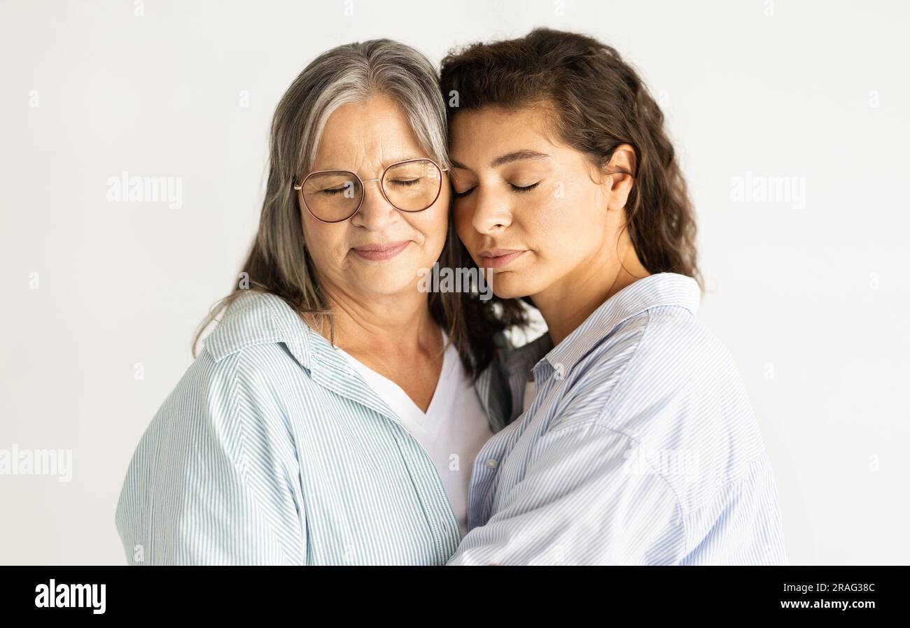 Positive calm pretty european adult and woman hugging old lady, enjoy ...
