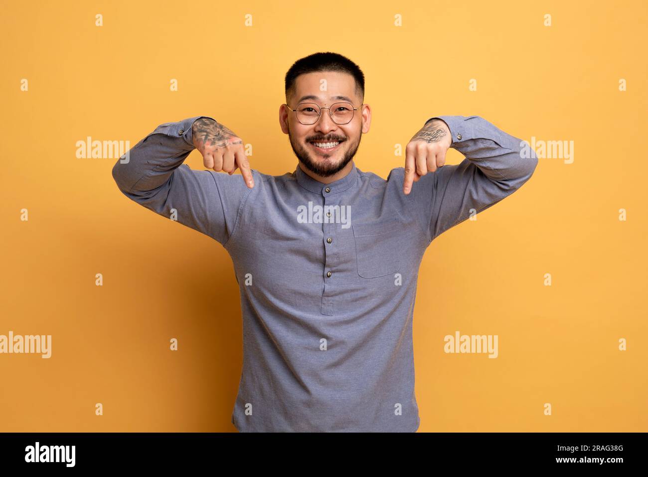 Look At This. Smiling Asian Guy Pointing Down With Two Hands Stock ...