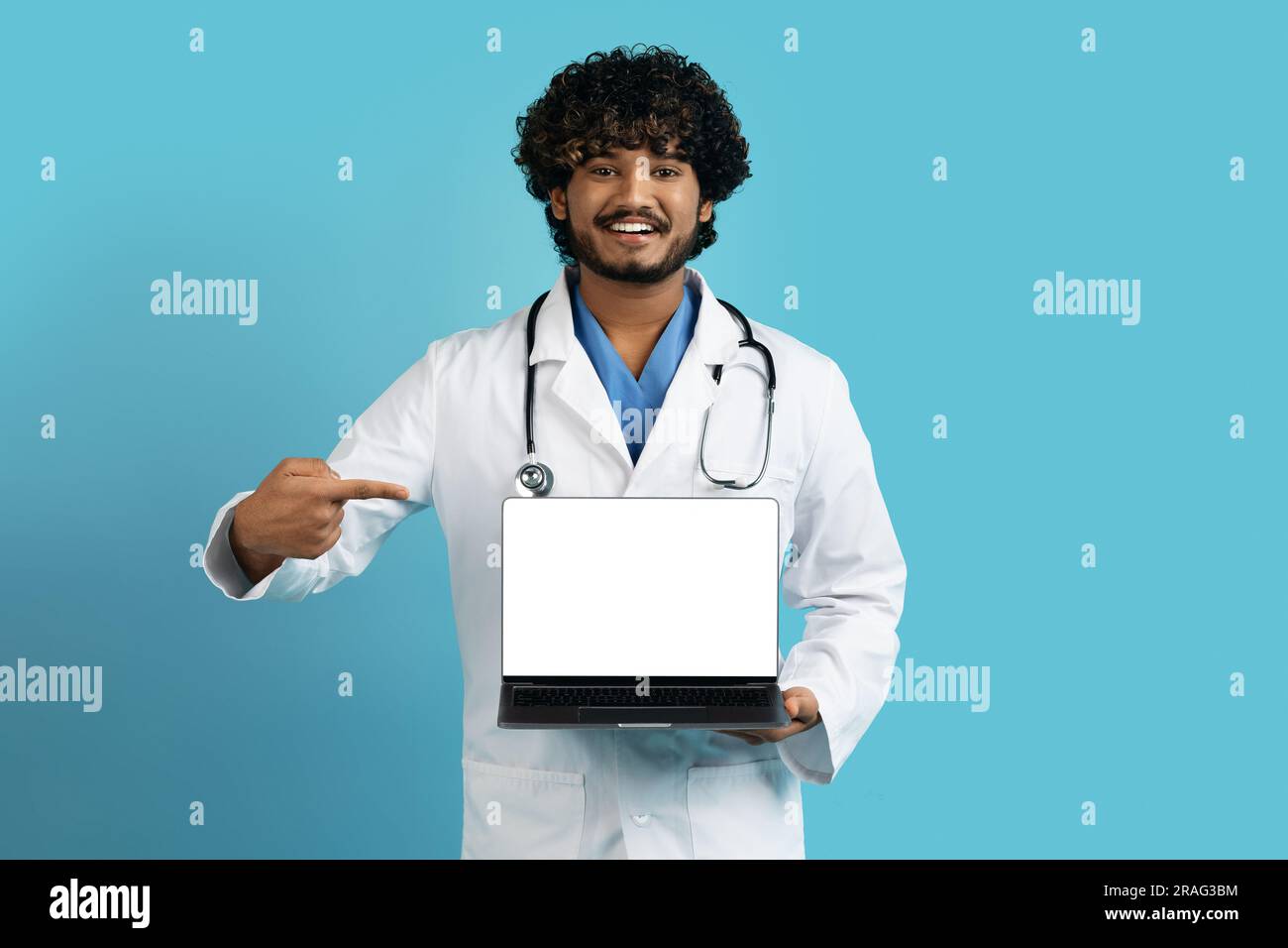 Smiling eastern doctor showing computer with white screen Stock Photo ...