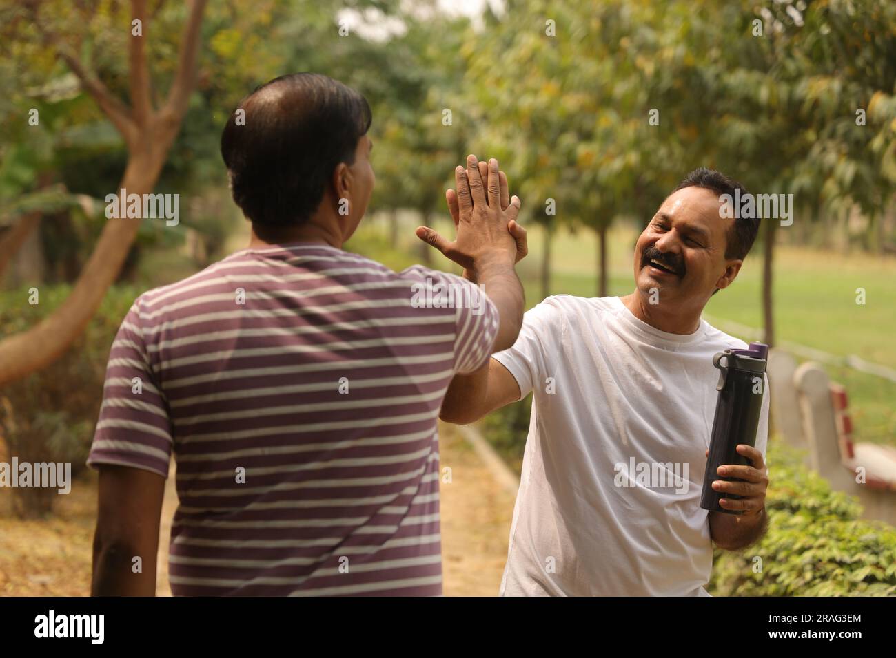 health conscious people and friends cheering up while jogging. They are ...
