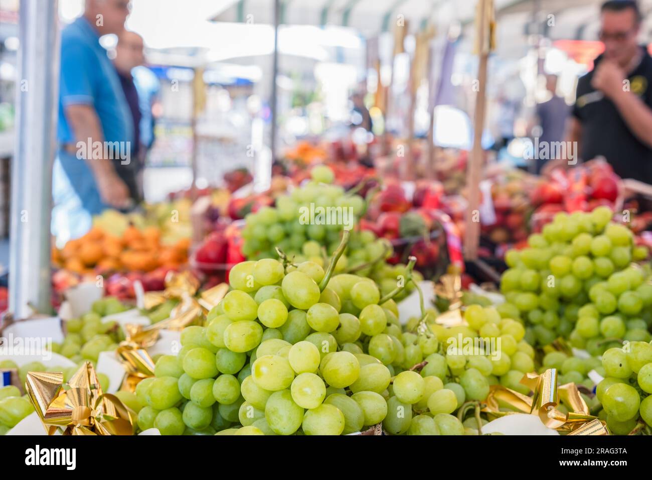 Grape on stall with selling fruit, food market, customers in blurred ...