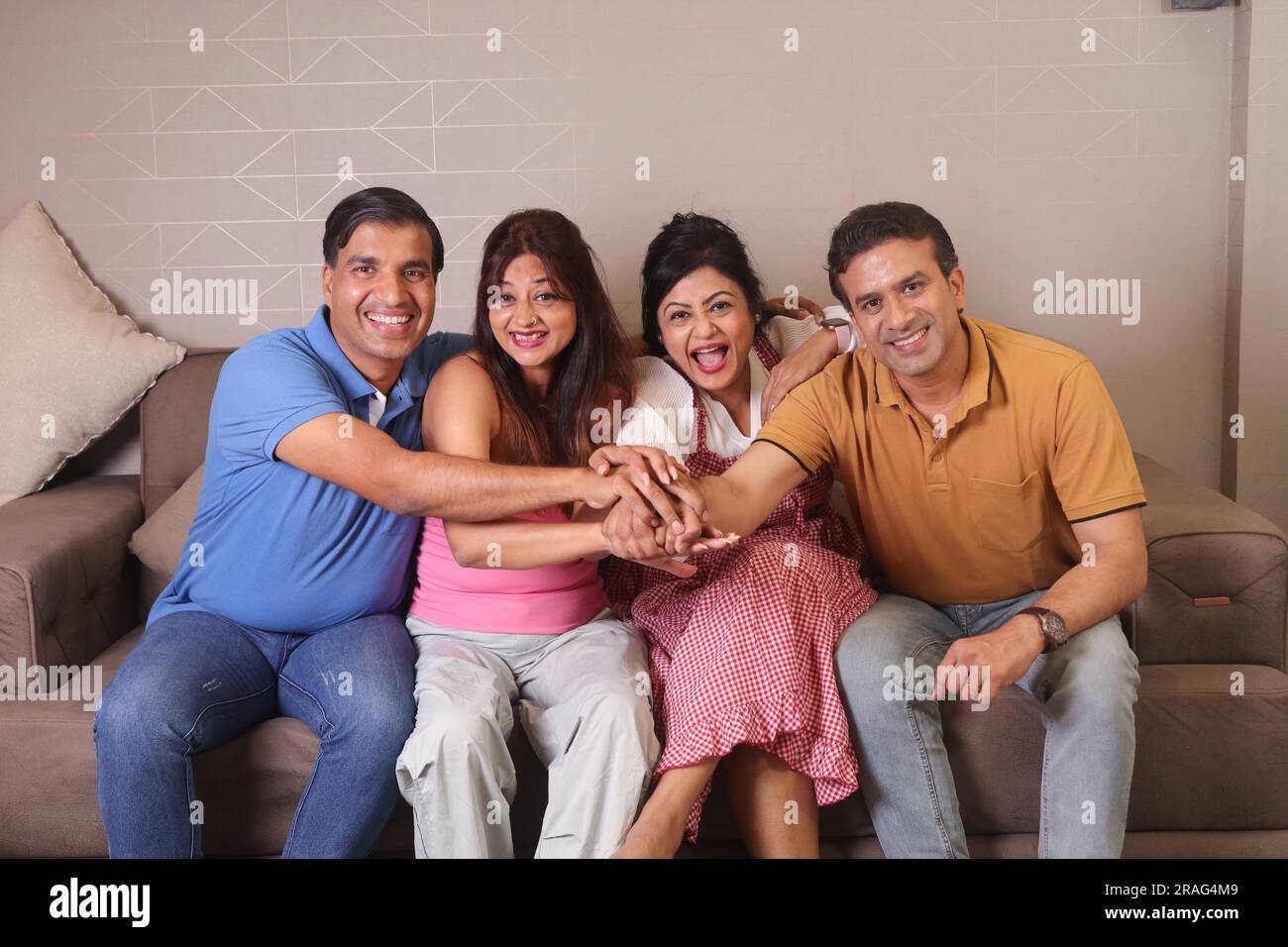 Happy Indian friends couples sitting on a couch enjoying watching match ...