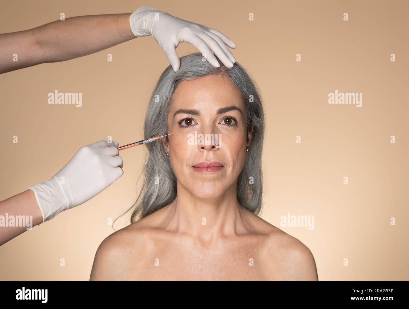 Cosmetologist doctor making botox injection for eyes area to senior ...