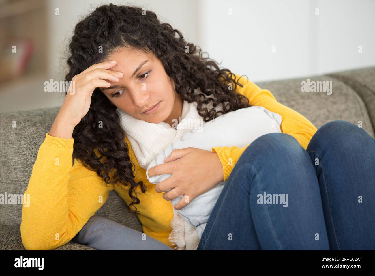 sad woman hugging a pillow Stock Photo - Alamy