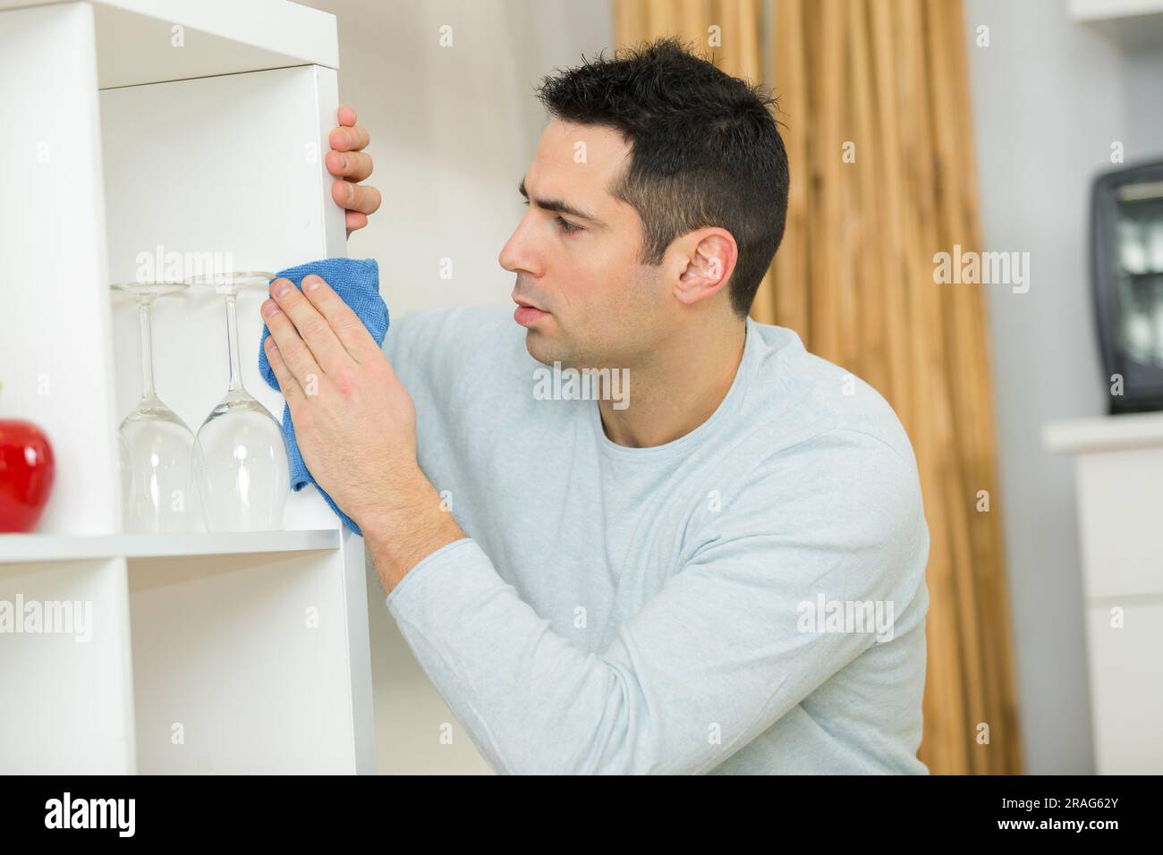 man cleaning dust from bookshelf Stock Photo - Alamy