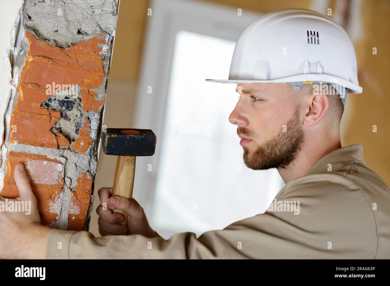 worker knocks the remains of plaster Stock Photo - Alamy