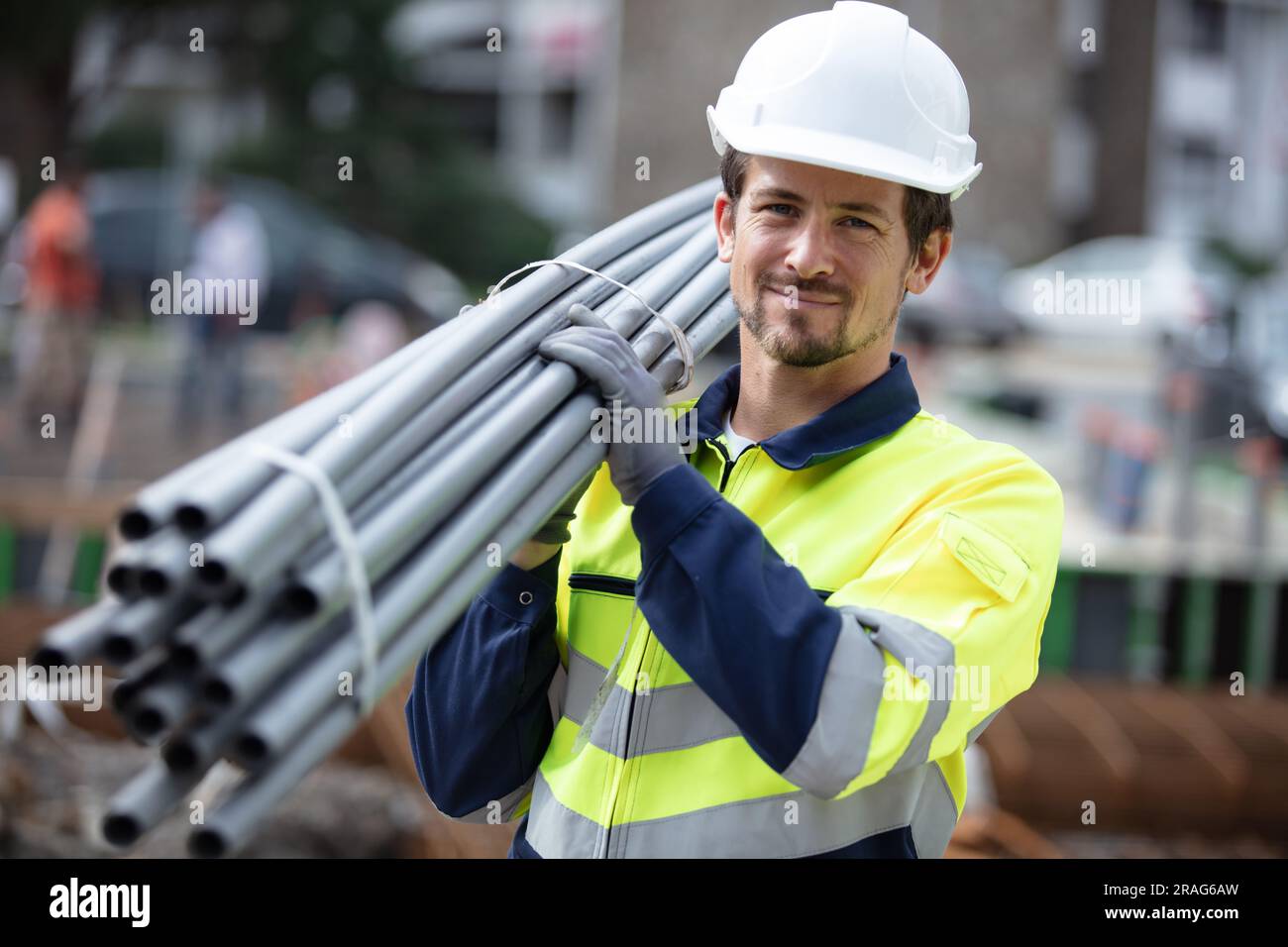 construction worker on site holding pipe Stock Photo - Alamy