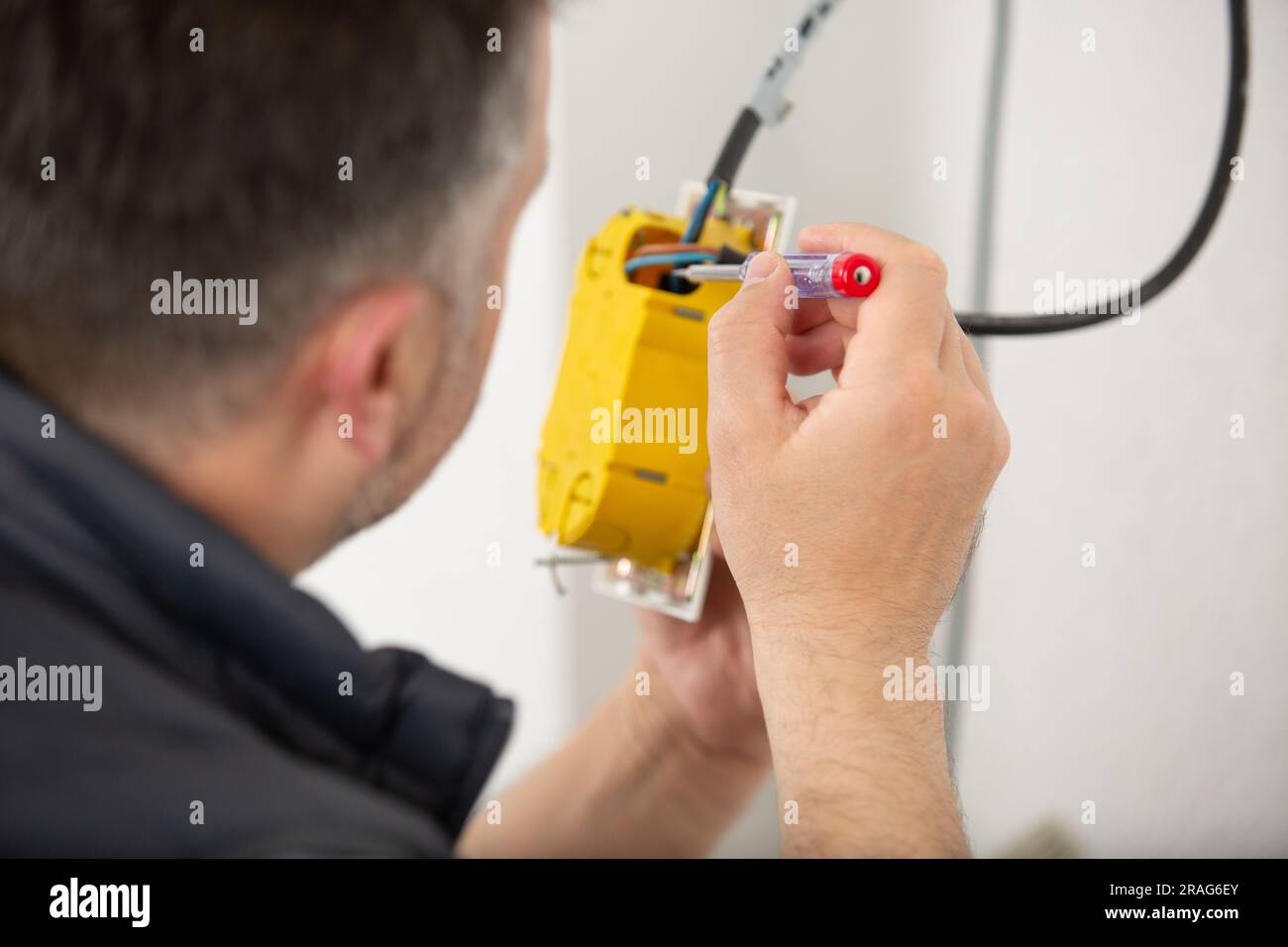 man using screwdriver in an electrical junction box Stock Photo - Alamy