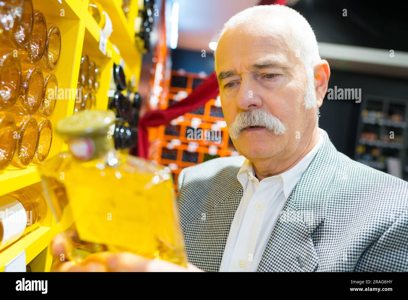 customer holding a bottle of yellow liquor Stock Photo - Alamy
