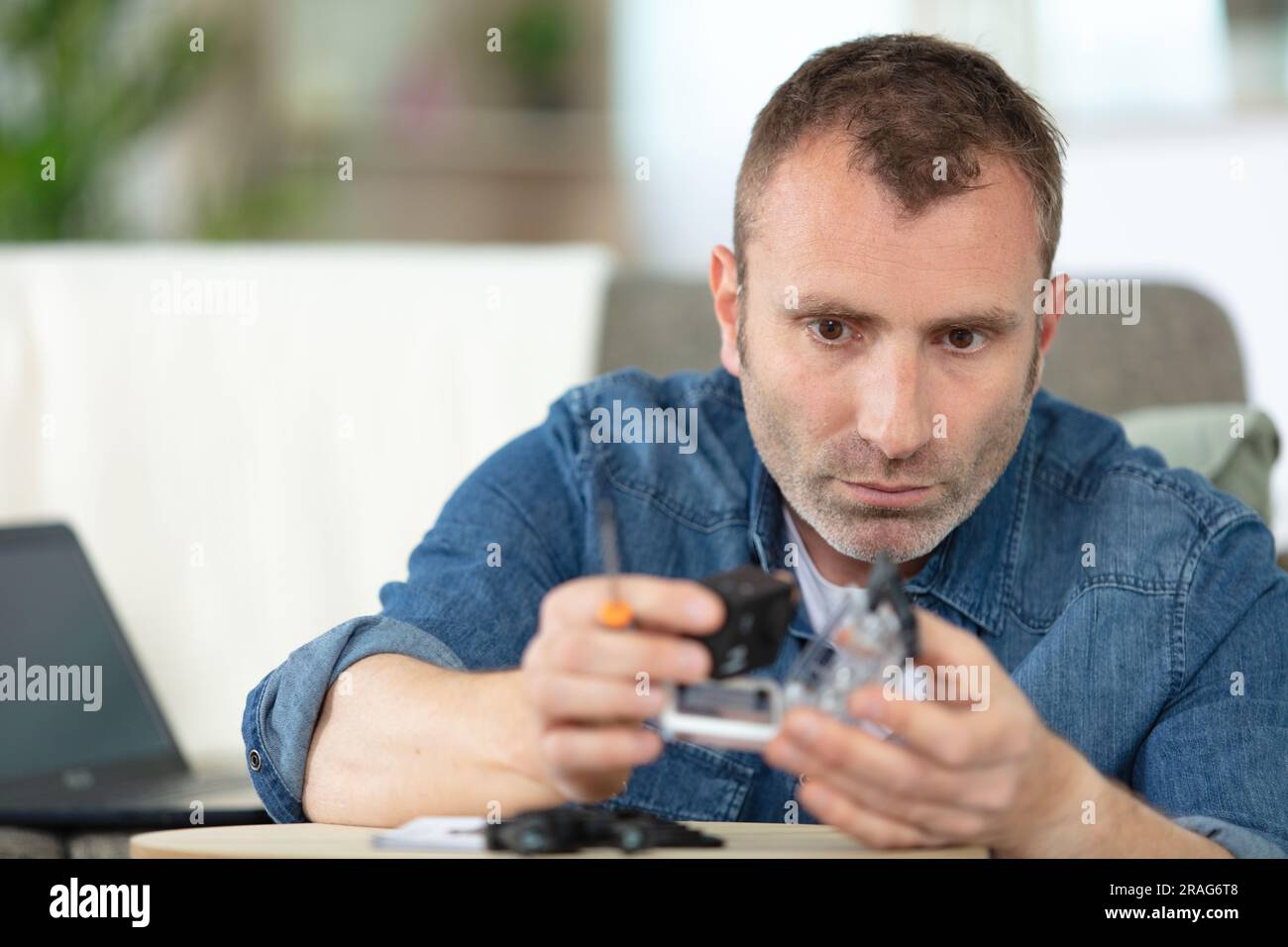 man repair small compact vidn©o camera Stock Photo - Alamy