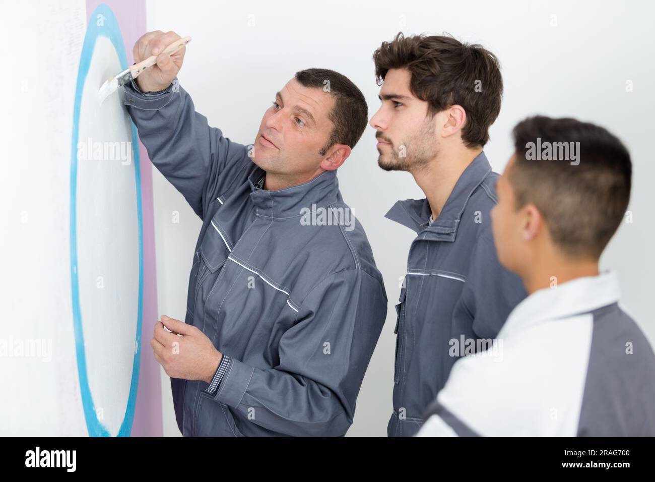industrial painter demonstrating technique to apprentice Stock Photo ...