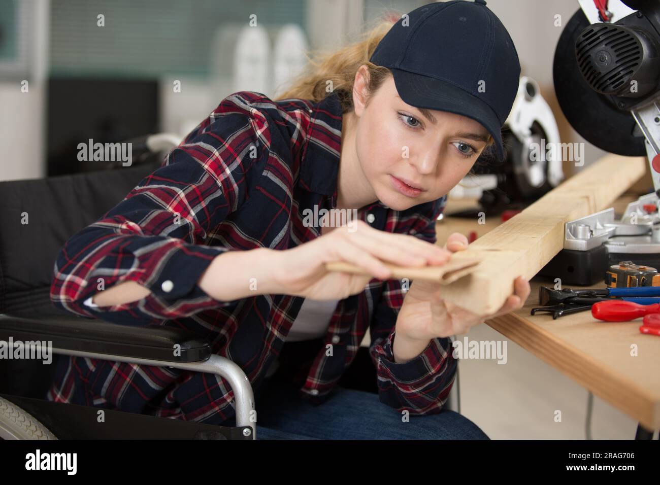 girl in wheelchair using sandpaper to smooth off wood Stock Photo - Alamy