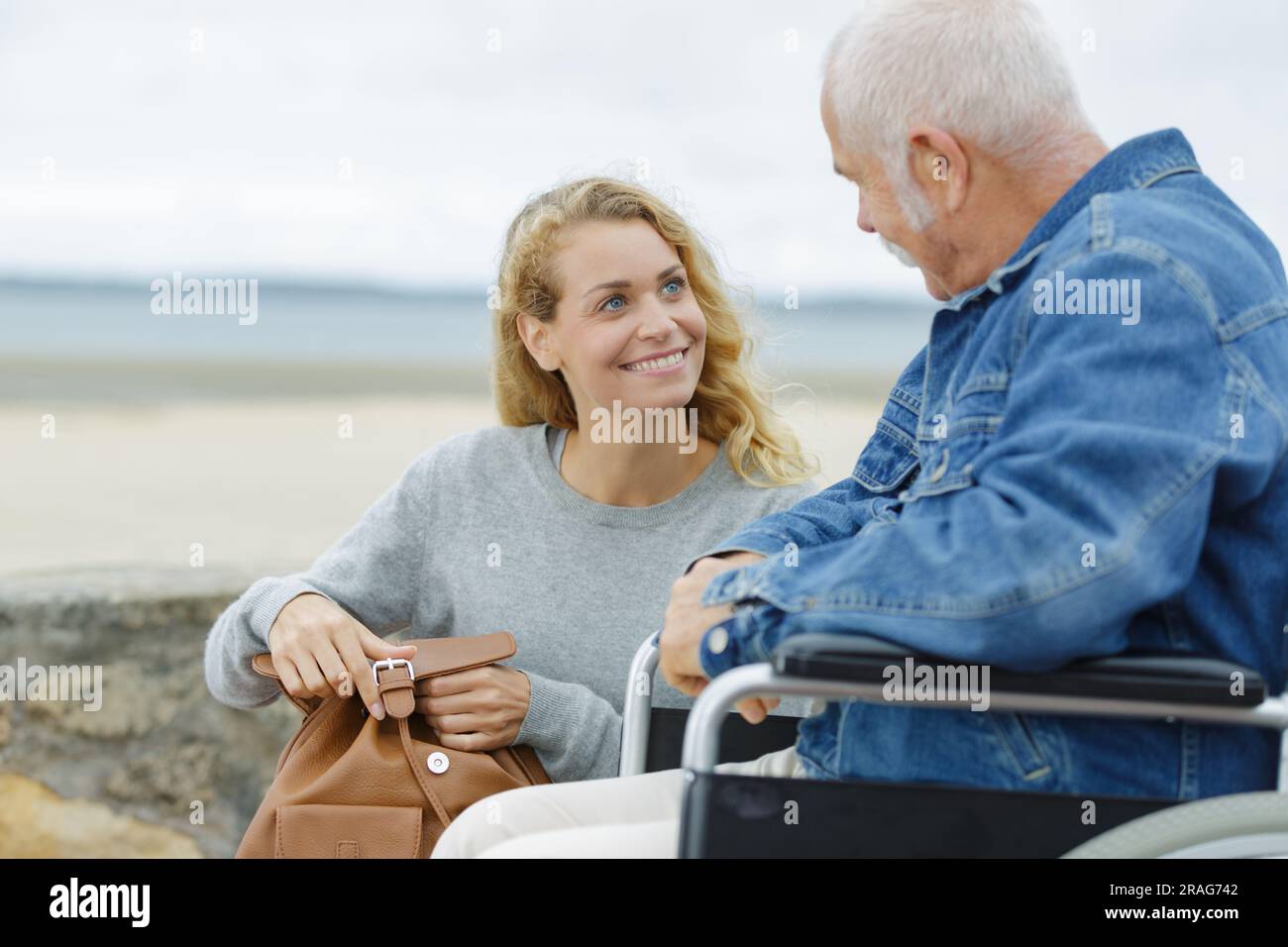 senior man in a wheelchair with beautiful caregiver Stock Photo - Alamy