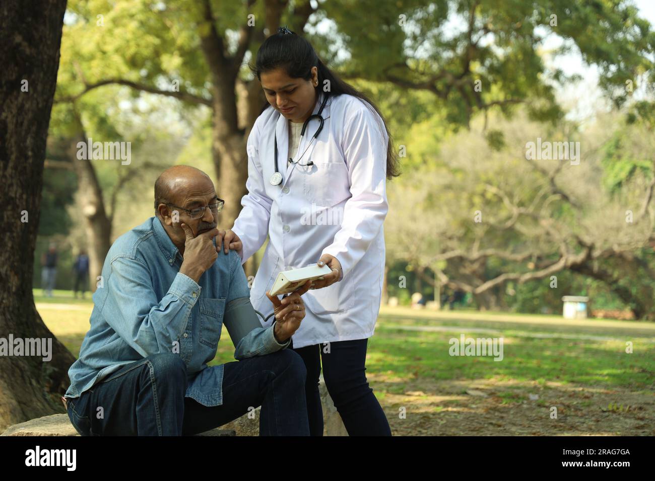 Doctor taking care of patient in city park hi-res stock photography and ...