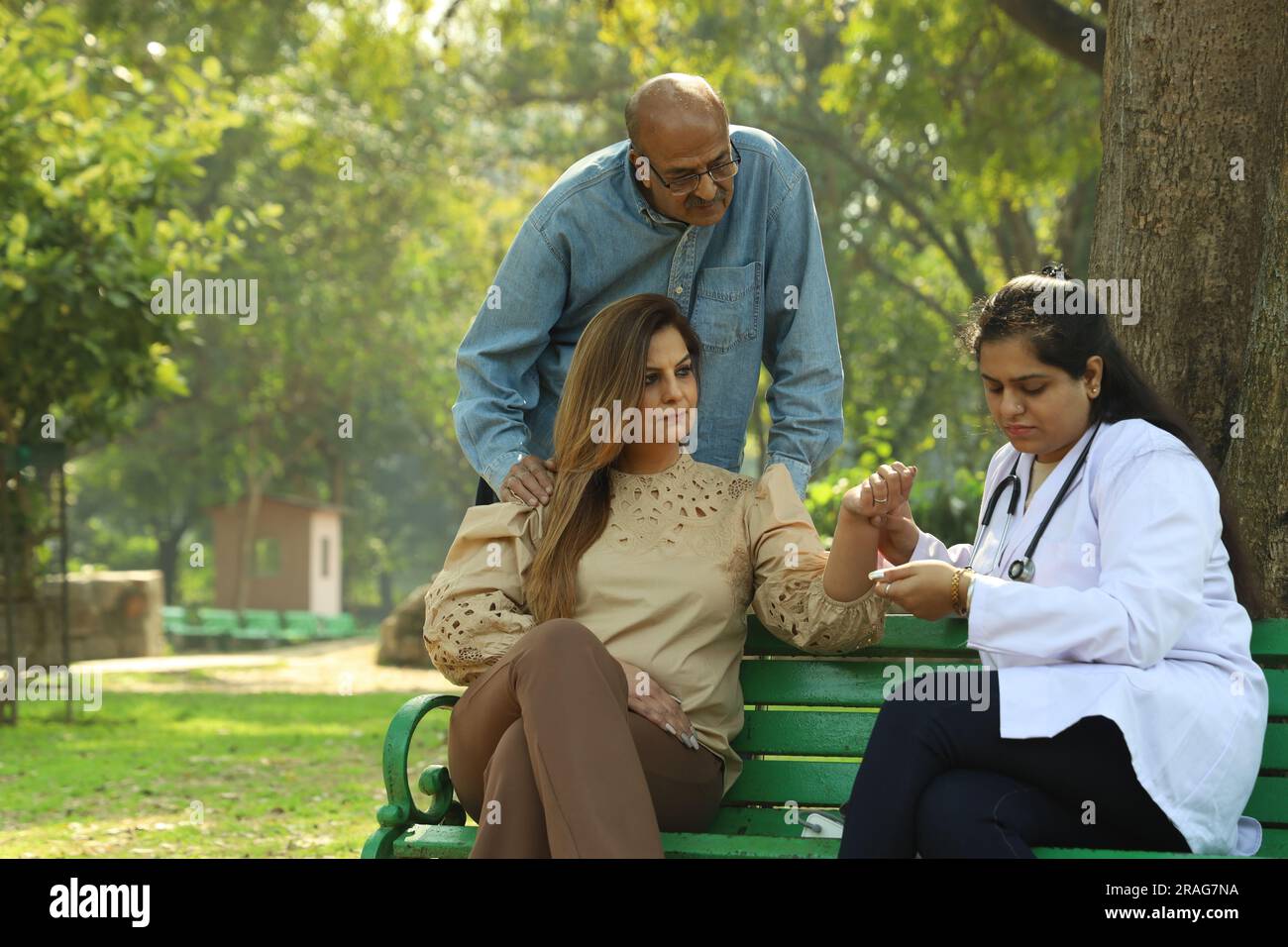 Doctor examining the patients in the city park amongst greens sitting ...