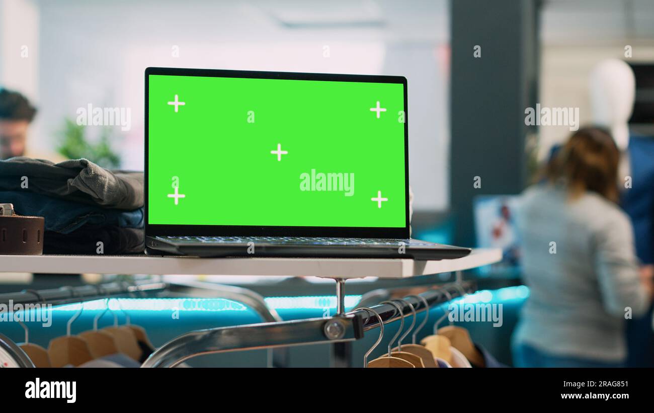 Modern laptop with greenscreen display in clothing store, running ...