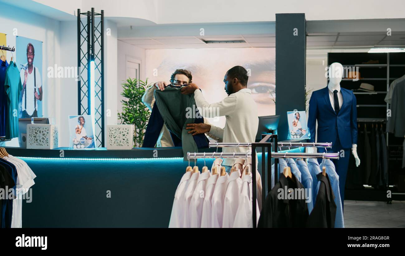 African american client paying for formal wear in store, standing at ...