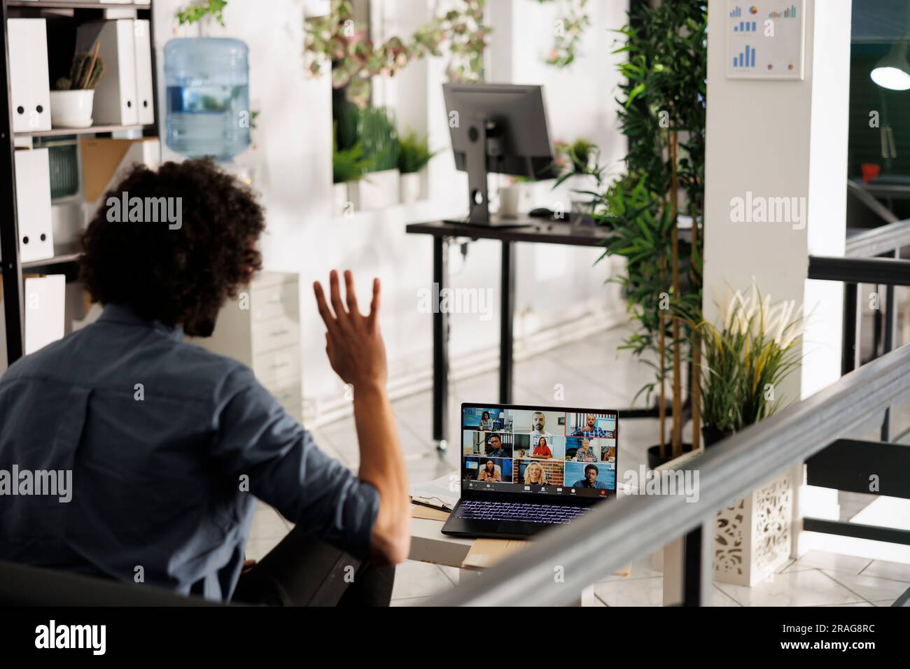 Employee having group video call, greeting diverse coworkers on laptop ...
