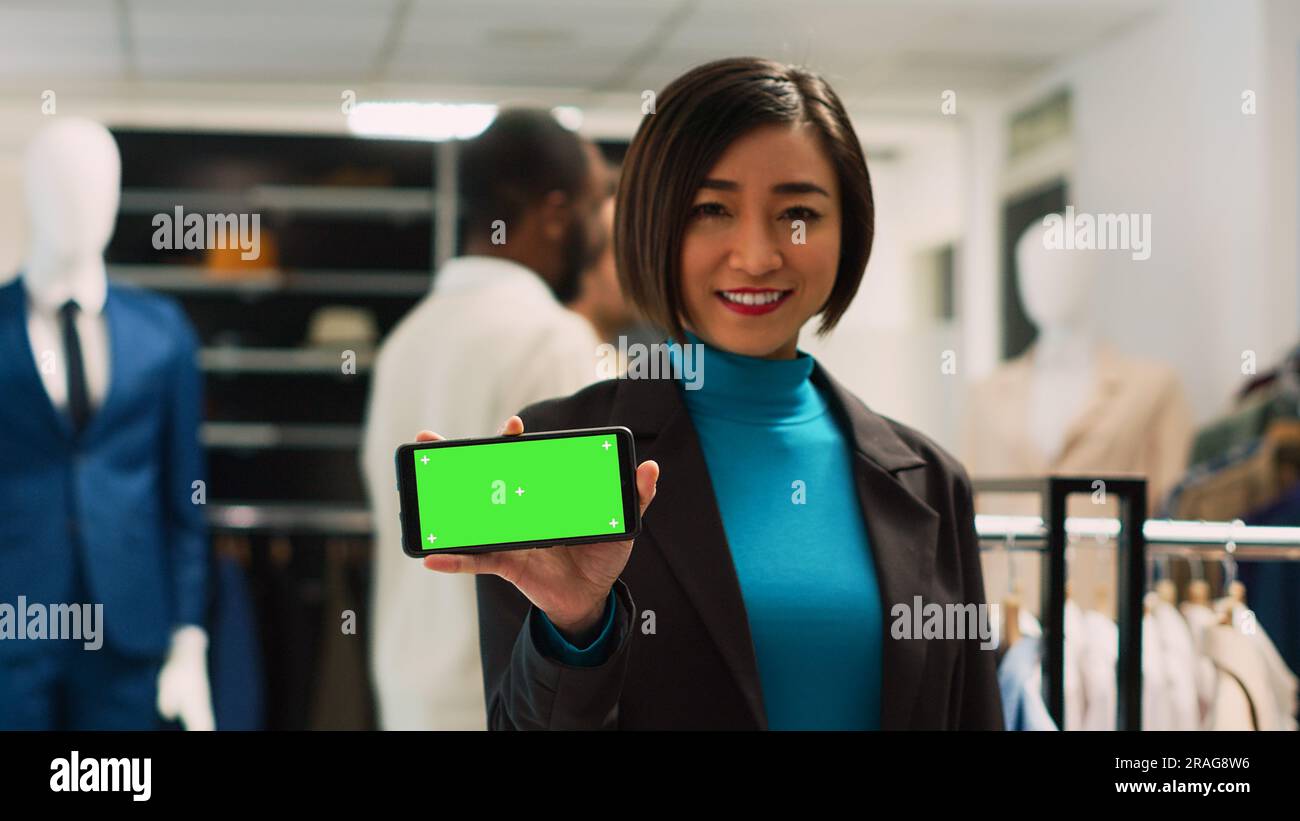 Asian woman holding isolated greenscreen display, showing chroma key ...