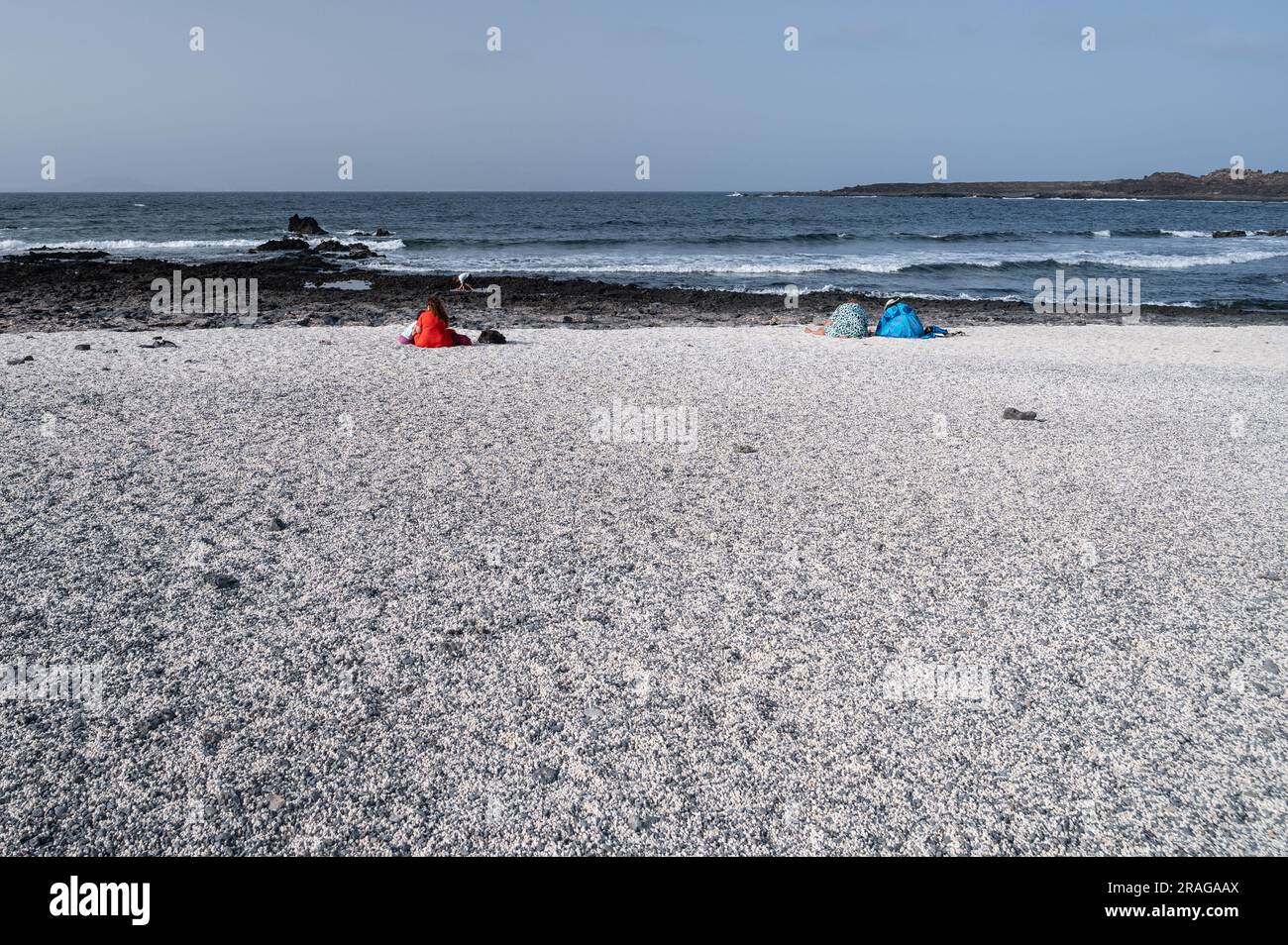 Tourists sitting on the "sand" present in "popcorn beach" which are ...