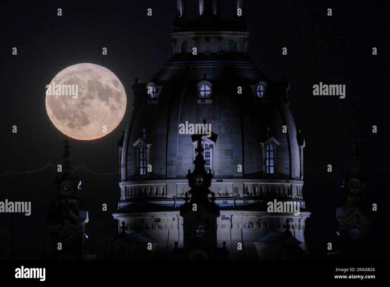 The full moon rises in the evening in the sky behind the Frauenkirche ...