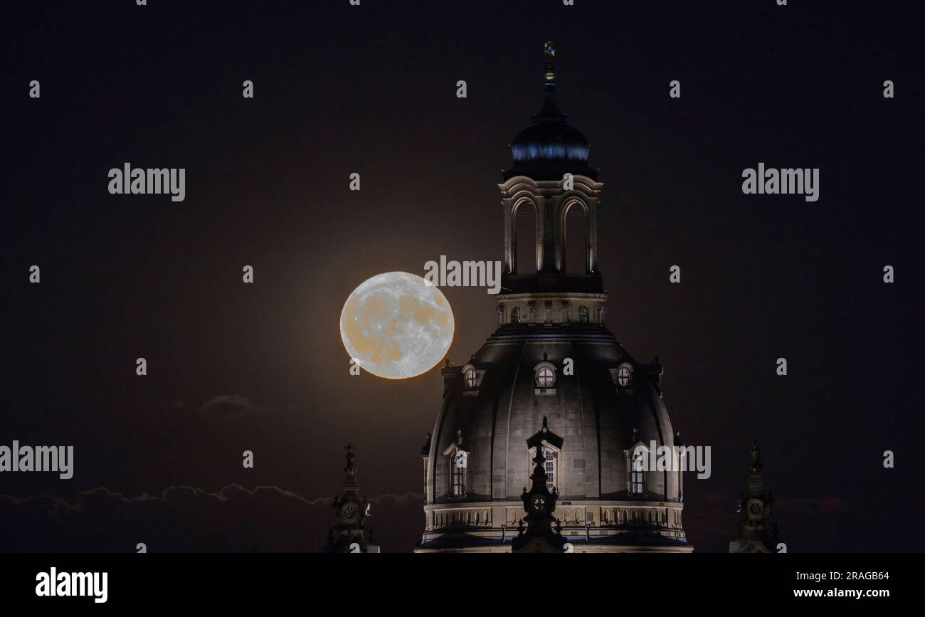 The full moon rises in the evening in the sky behind the Frauenkirche ...