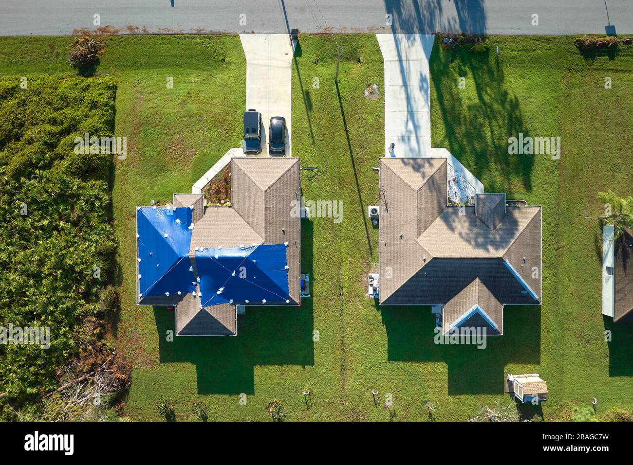 Aerial view of damaged in hurricane Ian house roof covered with blue ...