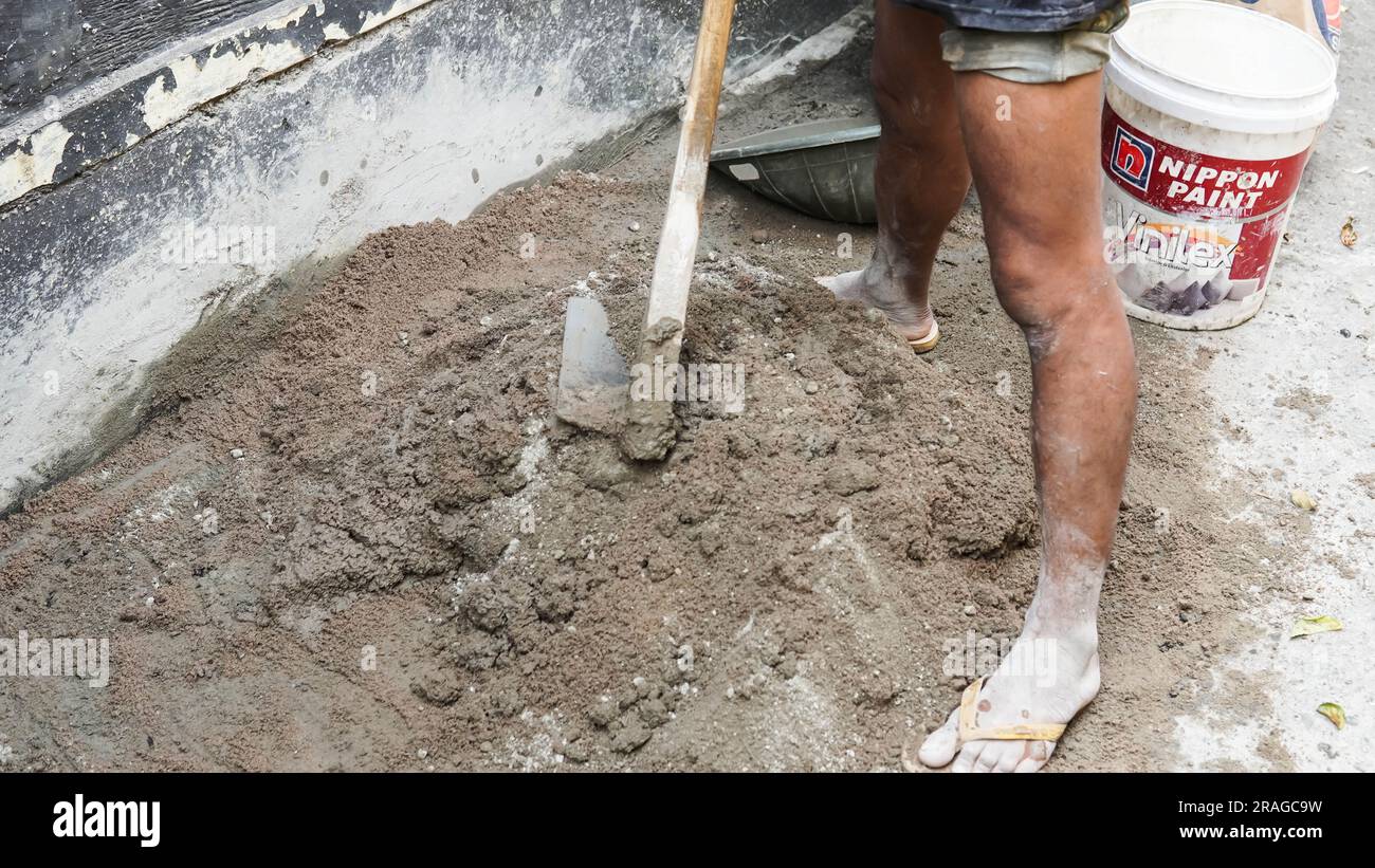 Asian worker using hoe for mixing cement power with sand Stock Photo ...