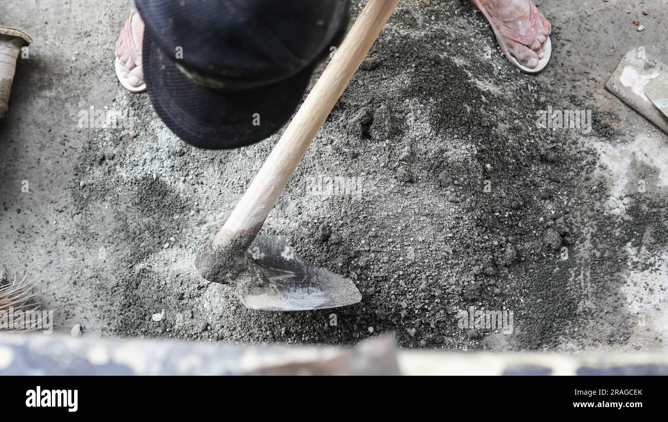 Asian worker using hoe for mixing cement power with sand Stock Photo ...
