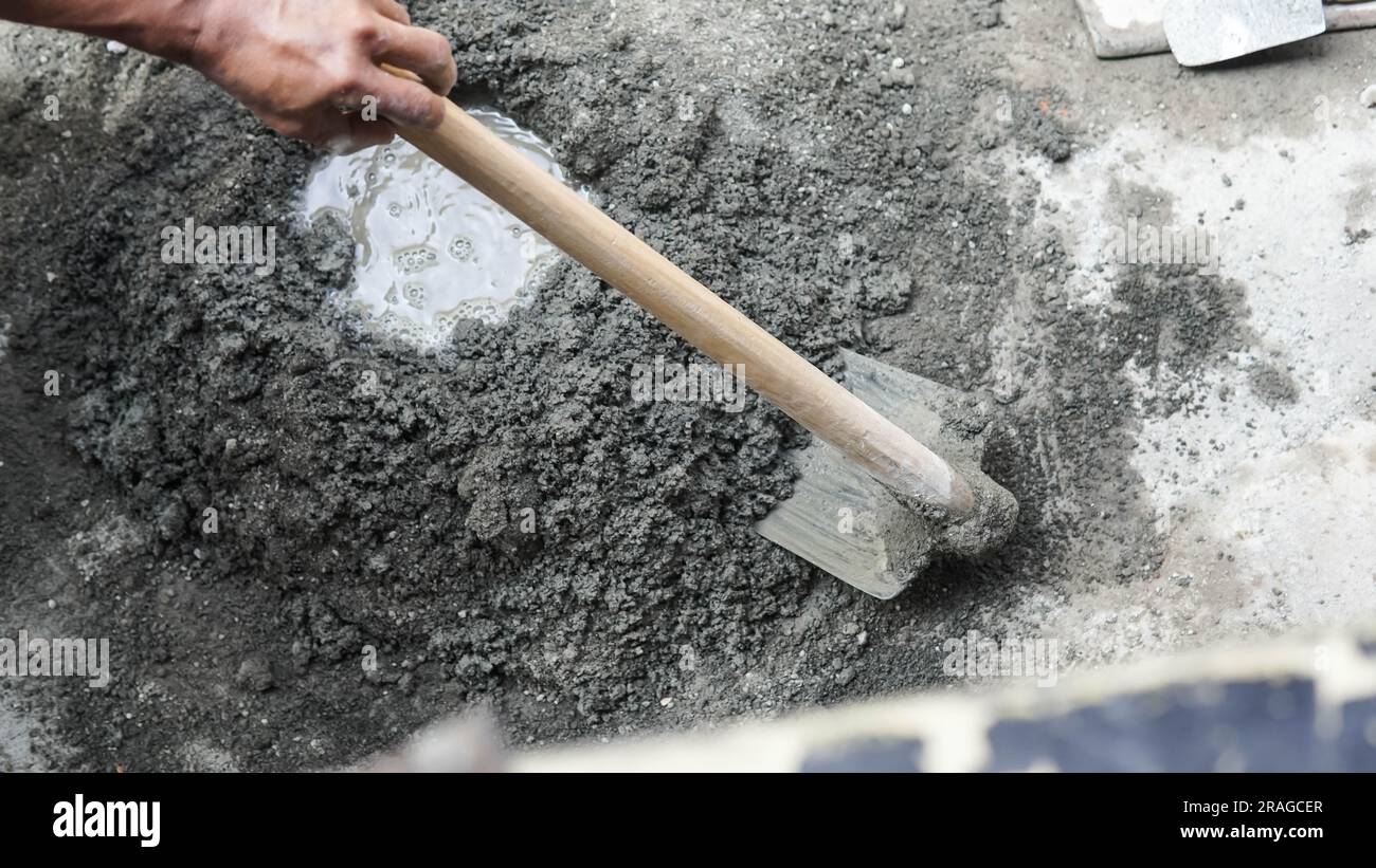 Asian worker using hoe for mixing cement power with sand Stock Photo ...