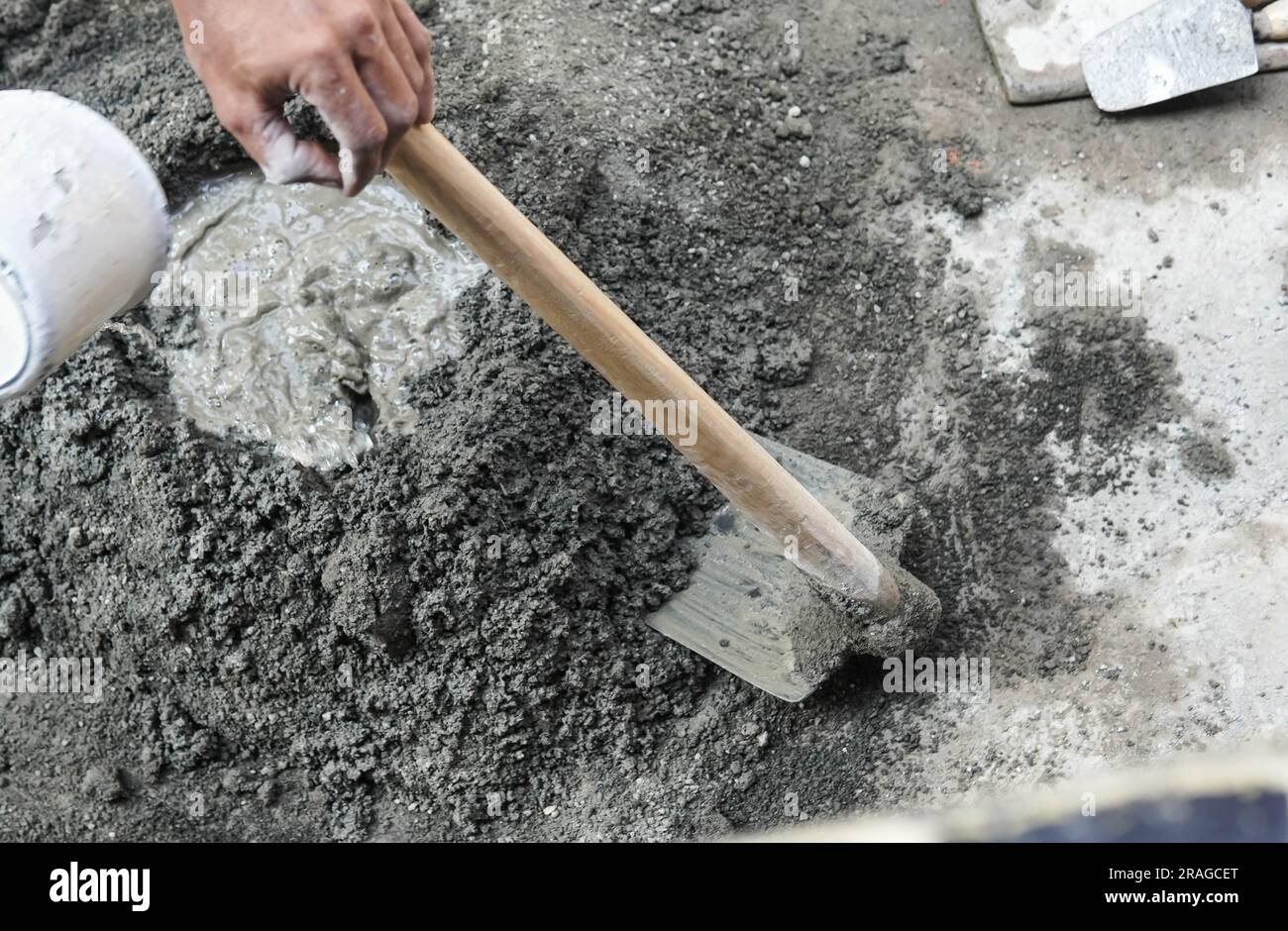 Asian worker using hoe for mixing cement power with sand Stock Photo ...