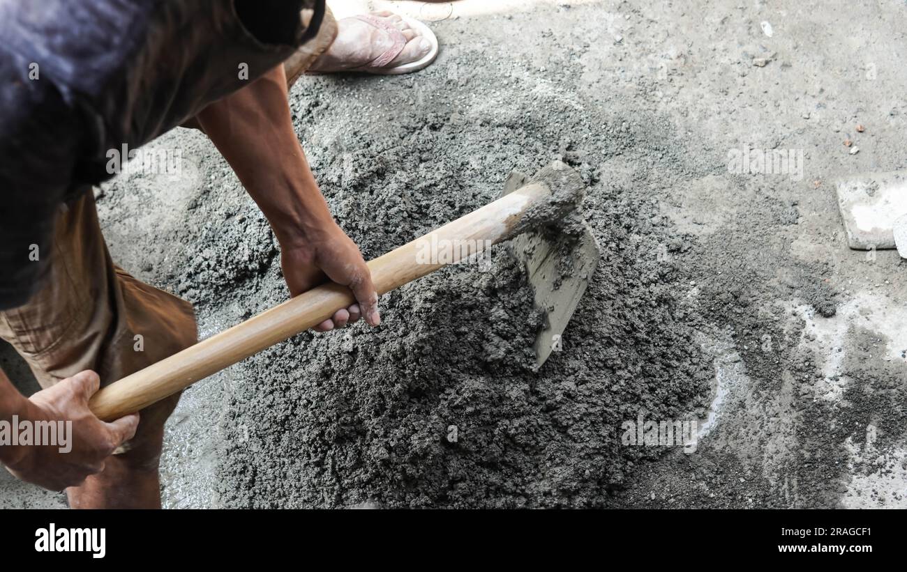 Asian worker using hoe for mixing cement power with sand Stock Photo ...