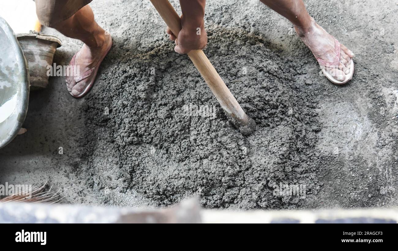 Asian worker using hoe for mixing cement power with sand Stock Photo ...