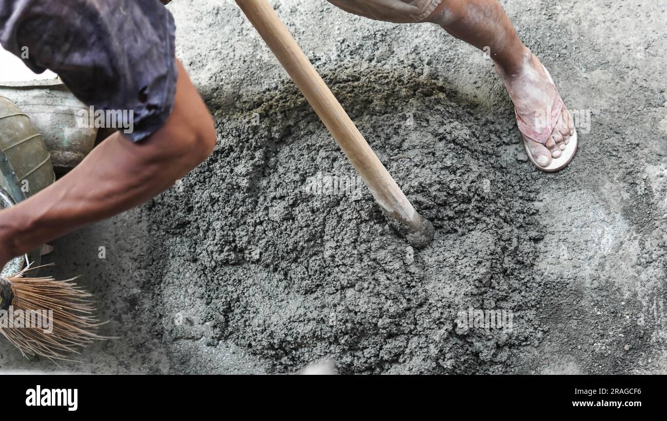 Asian worker using hoe for mixing cement power with sand Stock Photo ...