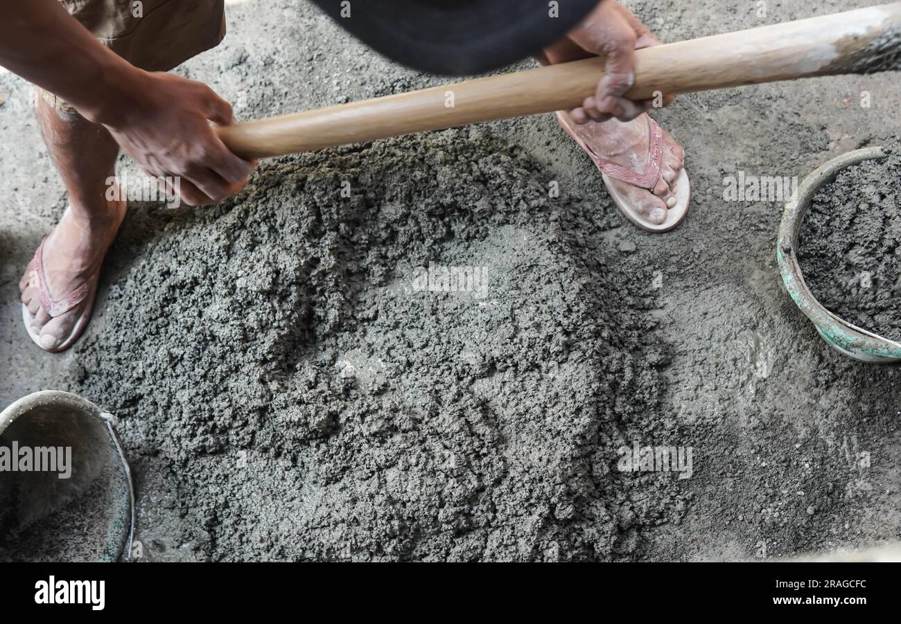 Asian worker using hoe for mixing cement power with sand Stock Photo ...