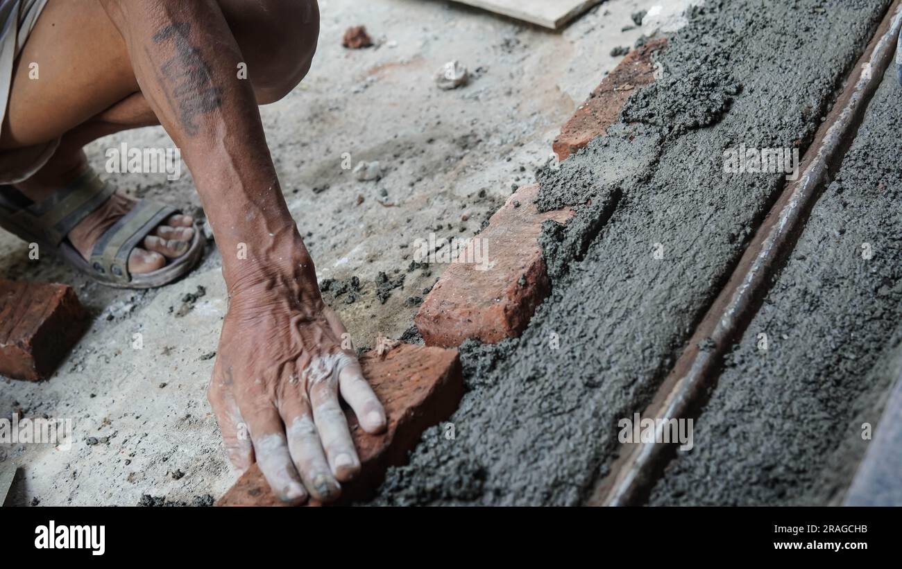 Worker or mason hands laying bricks close up. Bricklayer works at brick ...