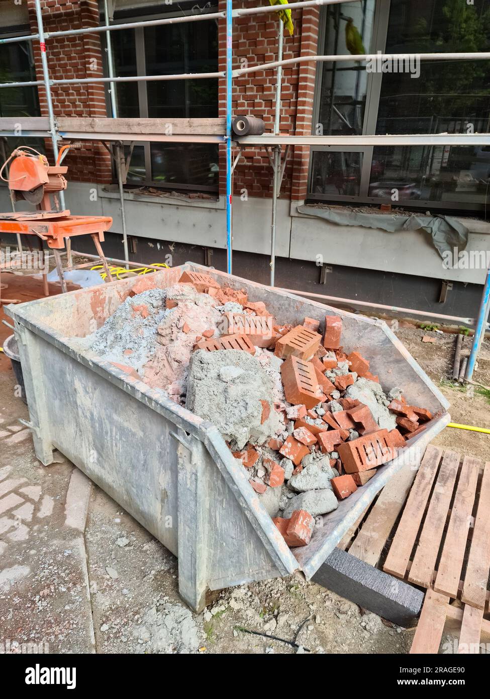 A container with rubble in front of a construction site Stock Photo - Alamy